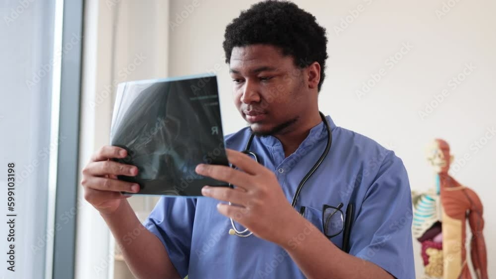 Mindful multiethnic male in scrubs wearing stethoscope and folded ...