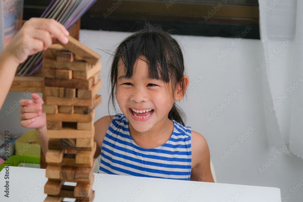 Cute Asian siblings having fun playing Jenga together. Two children ...