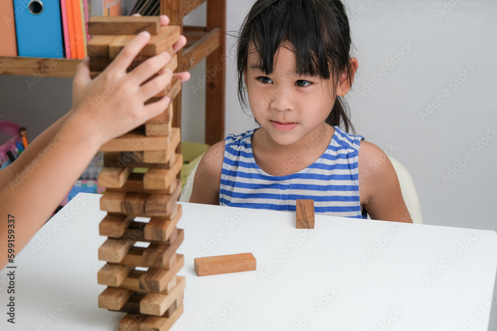Cute Asian siblings having fun playing Jenga together. Two children ...