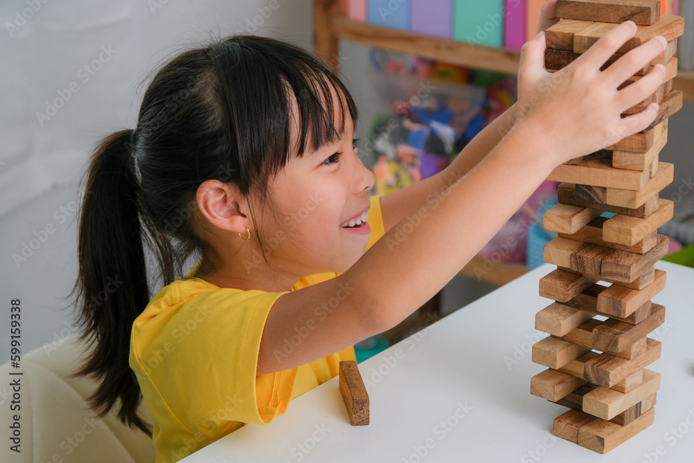 Cute Asian siblings having fun playing Jenga together. Two children ...