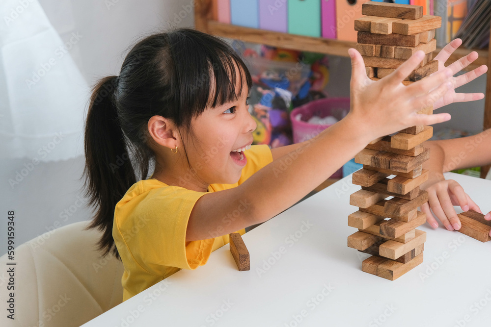 Cute Asian siblings having fun playing Jenga together. Two children ...