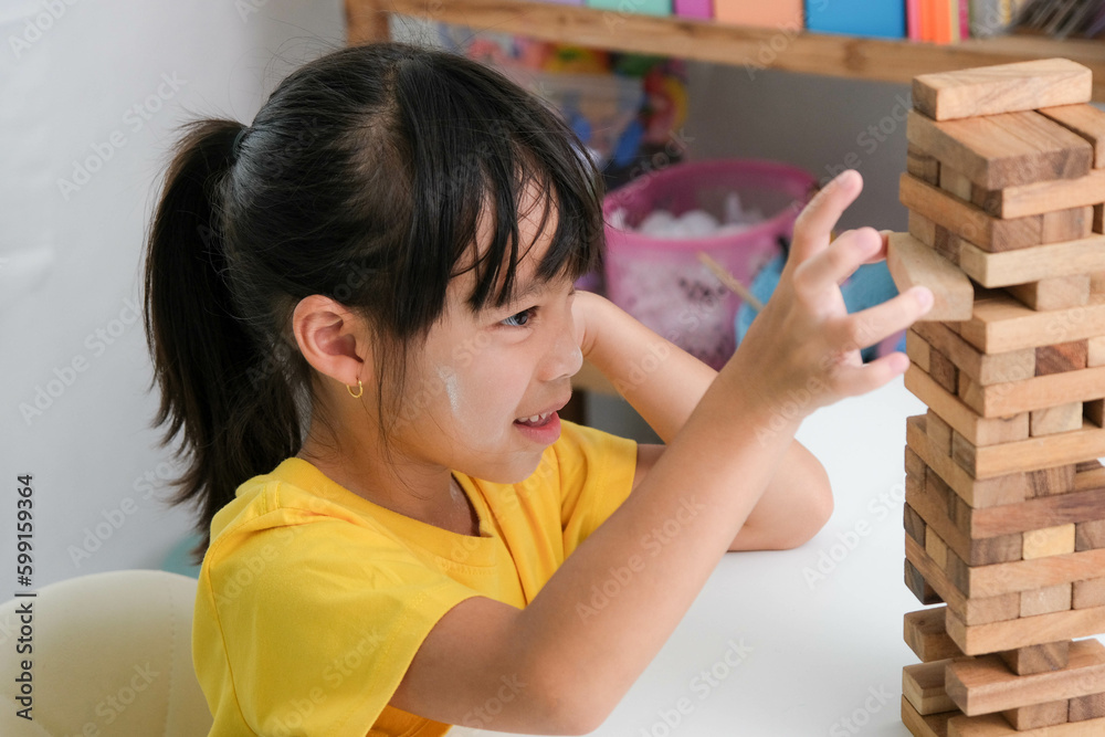 Cute Asian siblings having fun playing Jenga together. Two children ...
