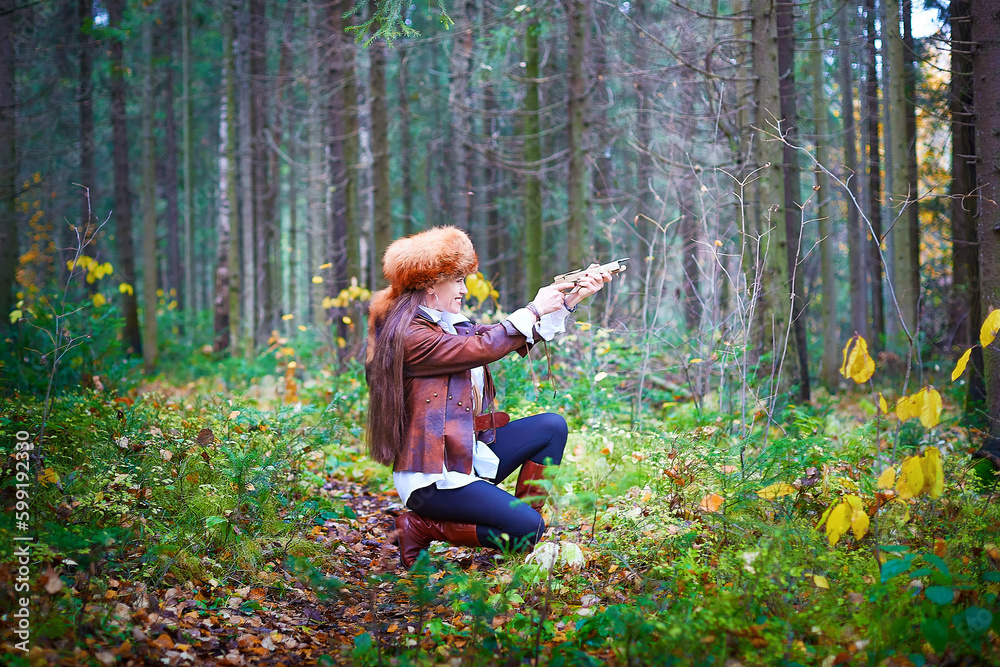 Girl in a leather jacket, a big red fox fur hat and with a crossbow in ...