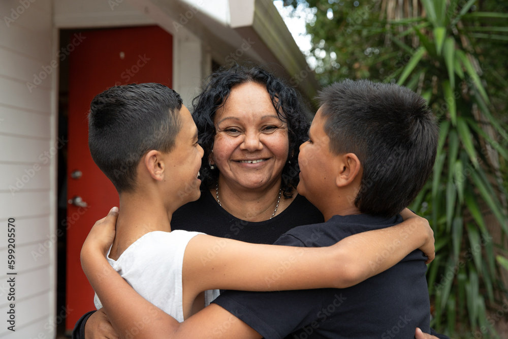 Aboriginal family hugging and kissing in backyard Stock Photo | Adobe Stock