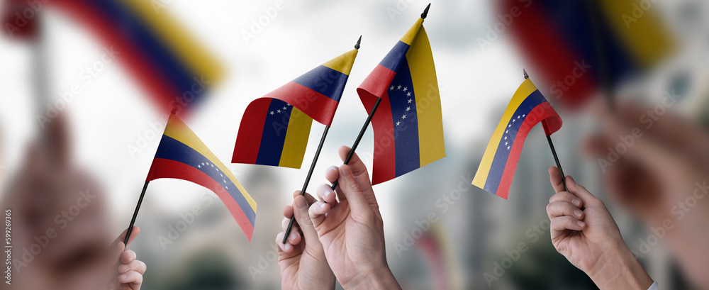 A group of people holding small flags of the Venezuela in their hands ...