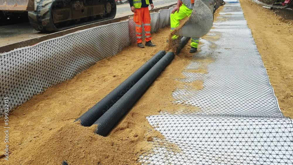 Groundworkers installing new electric ducts during roadworks on ...