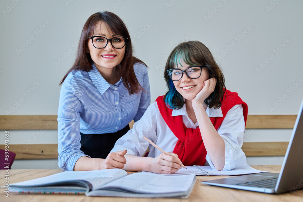 College student girl sitting with female teacher studying individually ...