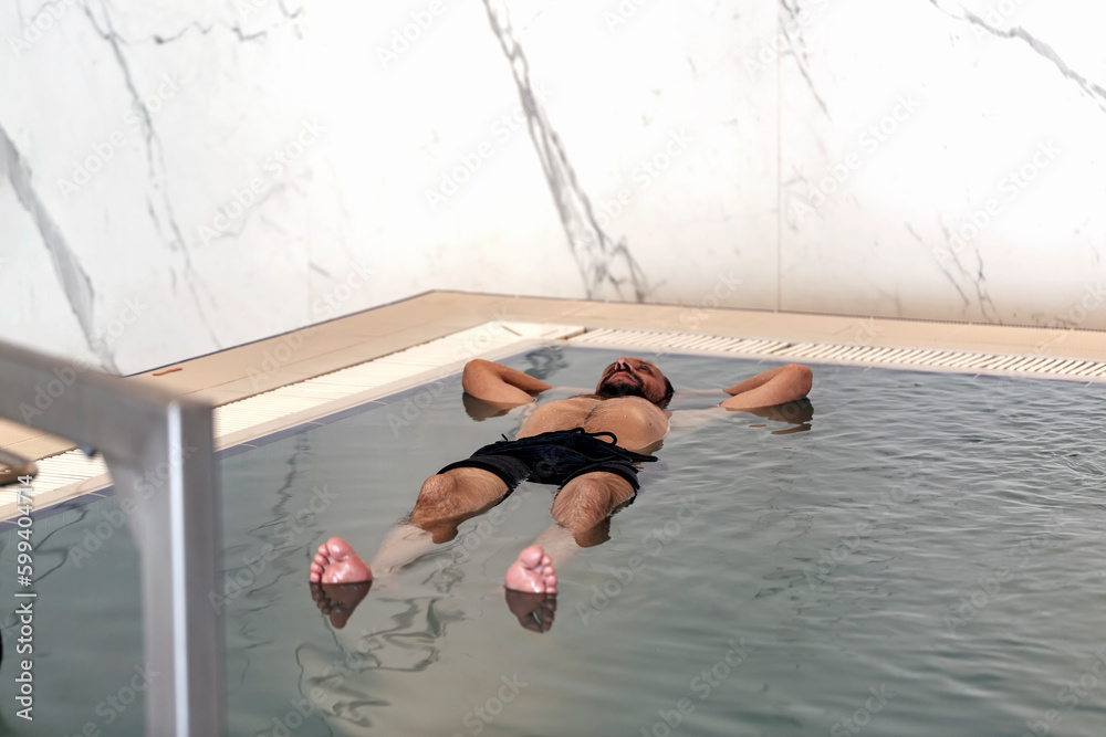 Adult caucasian man with beard, mustache floating in the swimming pool ...