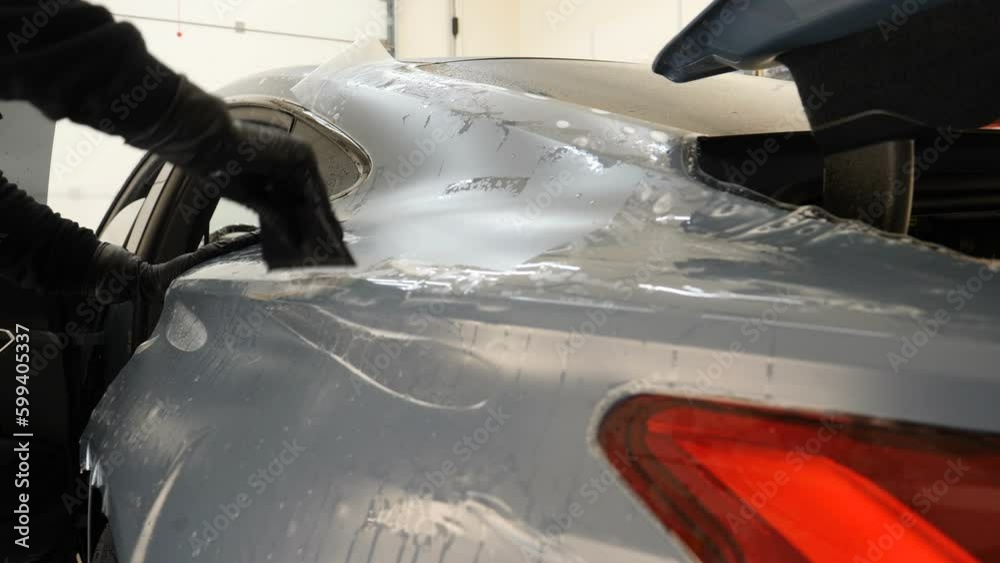 Close up to PPF installation process on a front headlight and hood. PPF ...