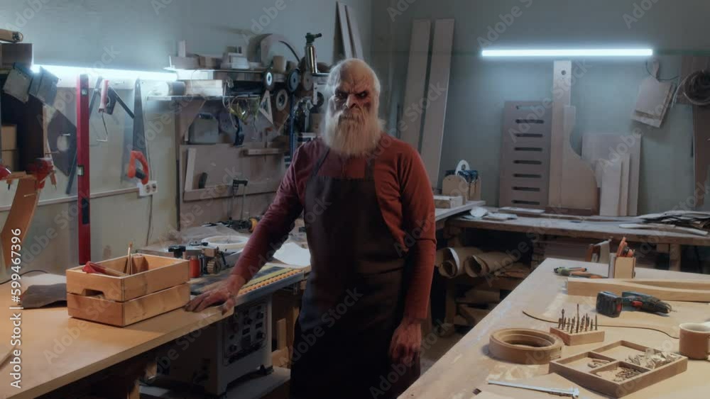 Conceptual portrait of bearded zombie carpenter standing in his ...