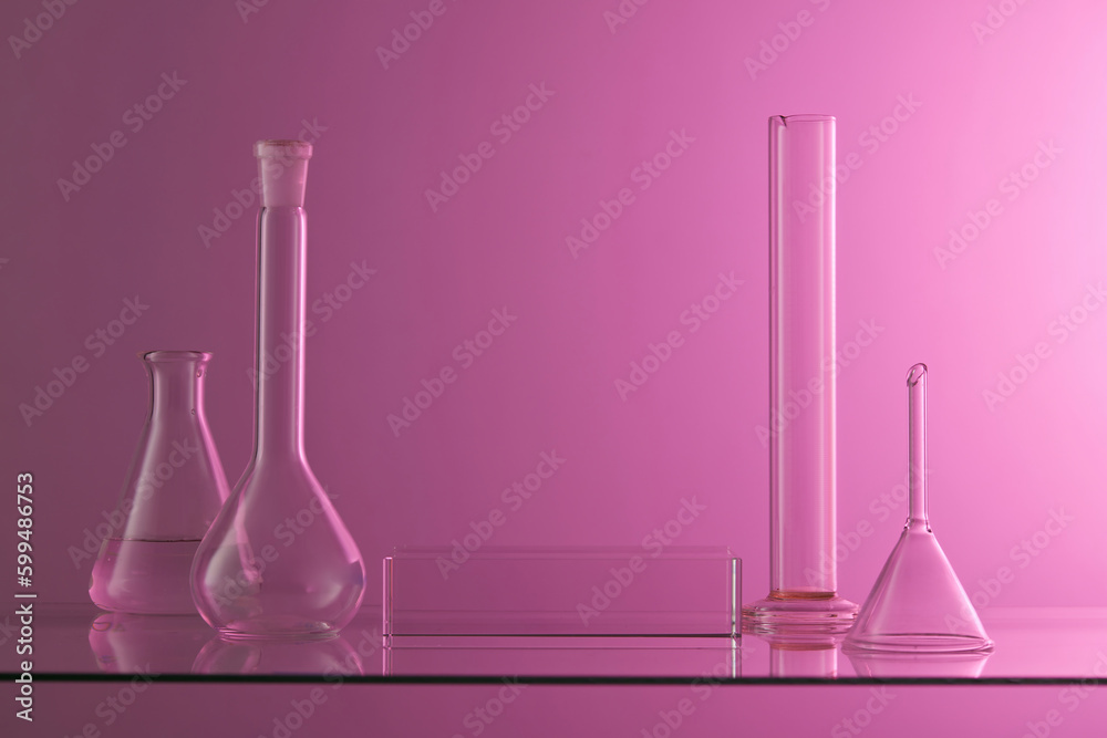 Laboratory concept with some flasks, glass funnel and tube. A ...