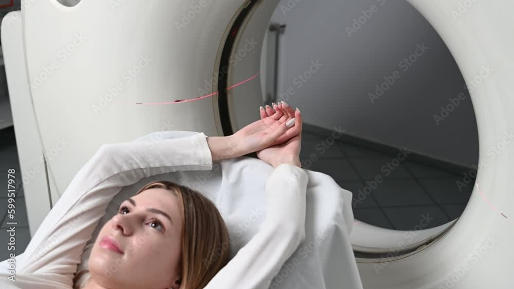 Young woman is undergoing a CT scan procedure. Pretty female in a ...