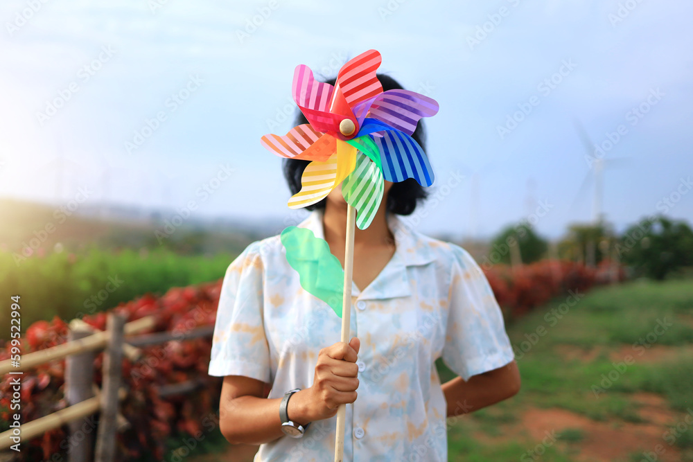 A woman shows a small windmill that covers her face to convey the ...