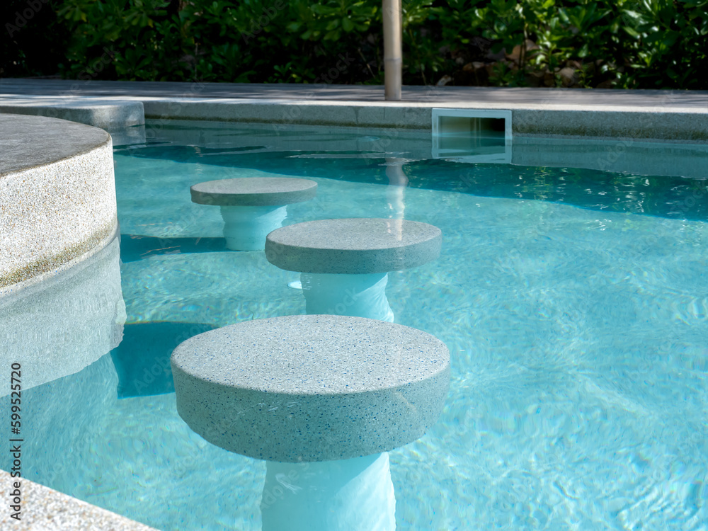 Empty round terrazzo bar stools seat in clean and clear water swimming ...