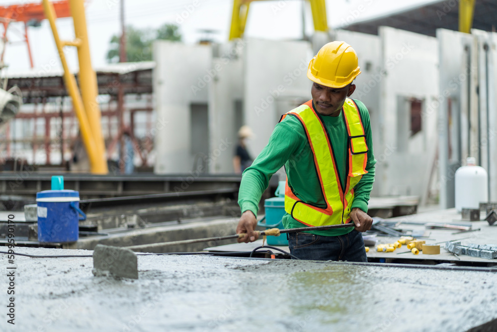 Male worker in a precast wall factory (Precast) is forming a wall with ...