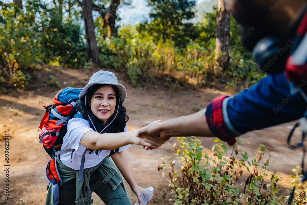 Woman hike being pulled up by helping hand. Hiker friends help each ...