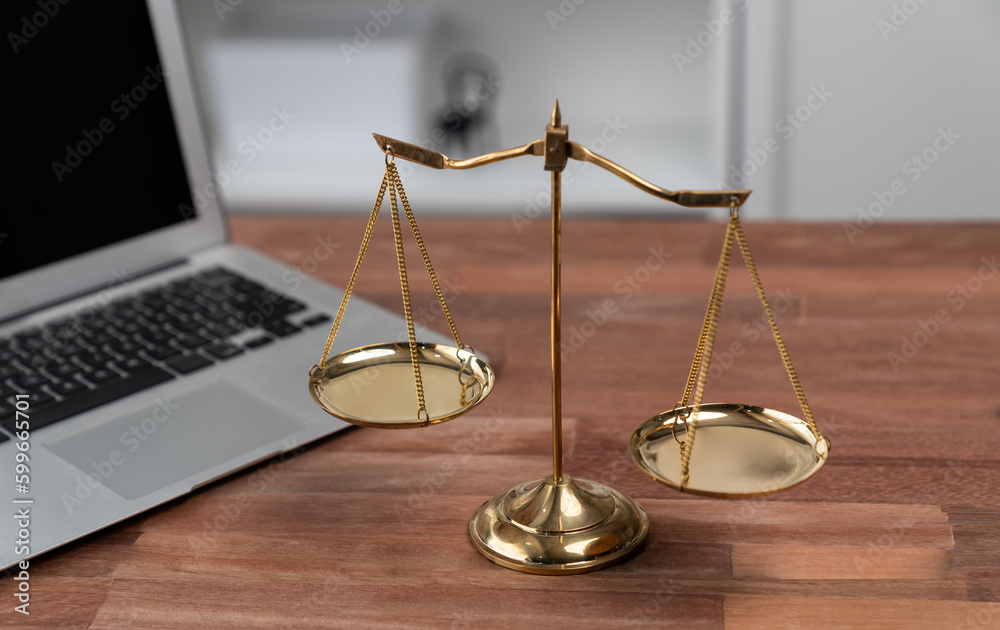Symbolizing justice and legal authority, golden balanced scale on desk ...