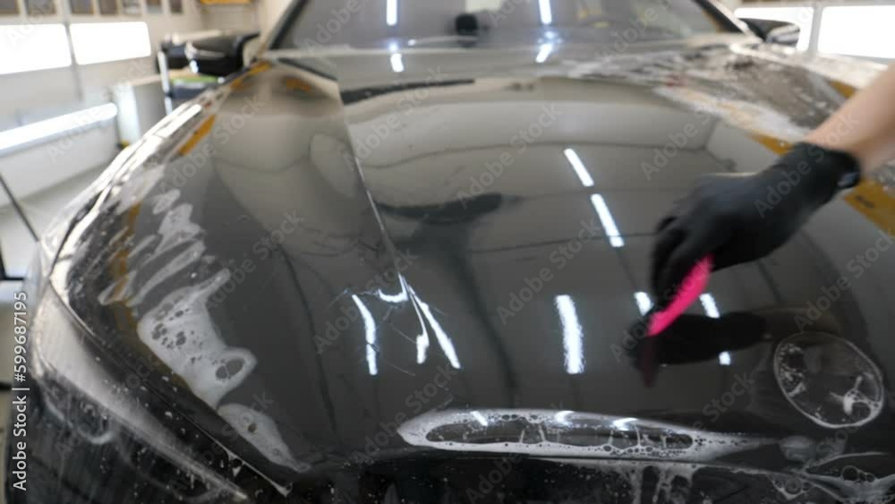 Close up to PPF installation process on a front headlight and hood. PPF ...