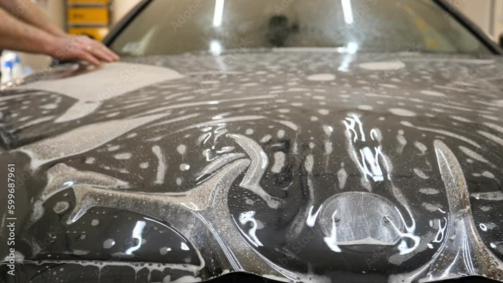 Close up to PPF installation process on a front headlight and hood. PPF ...