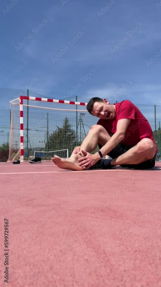 Sprain twisted ankle. Futsal sport injury. Male touching foot in pain ...