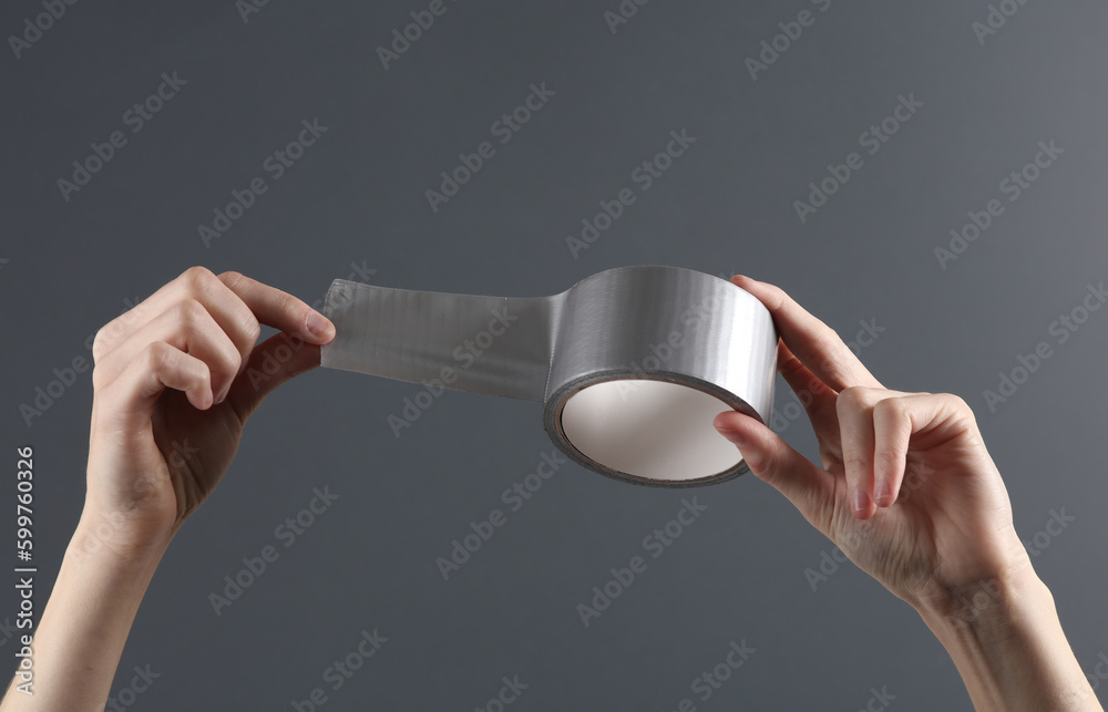 Hand holding duct tape on gray background Stock Photo | Adobe Stock