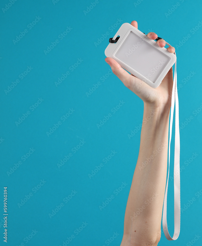 Hand holding id card badge with strap on blue background Stock Photo ...