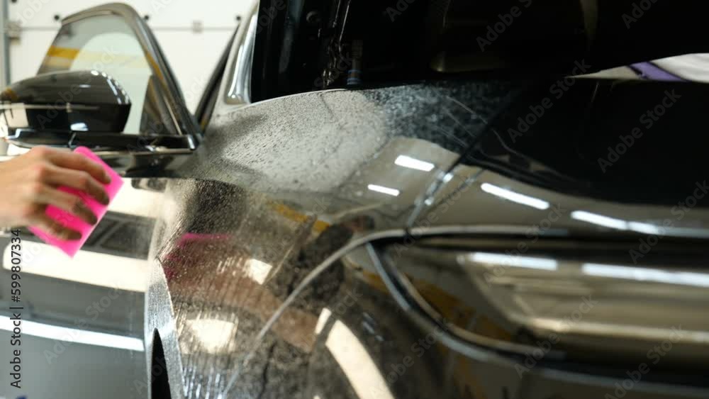 Close up to PPF installation process on a front headlight and hood. PPF ...