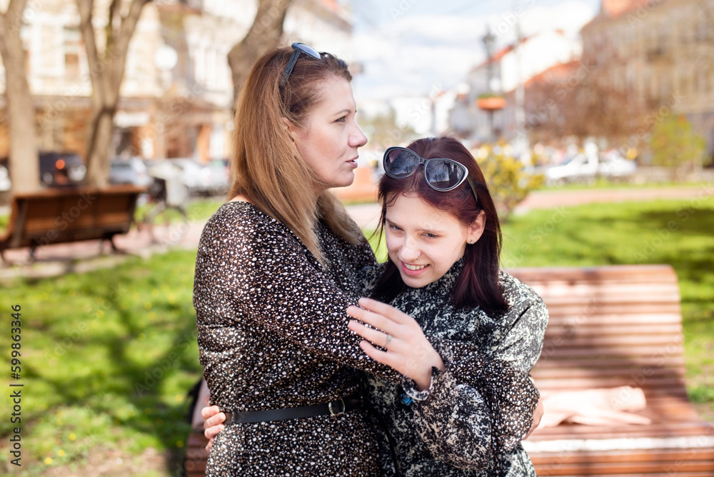 A middle-aged woman hugs her teenage daughter and gives her encouraging ...