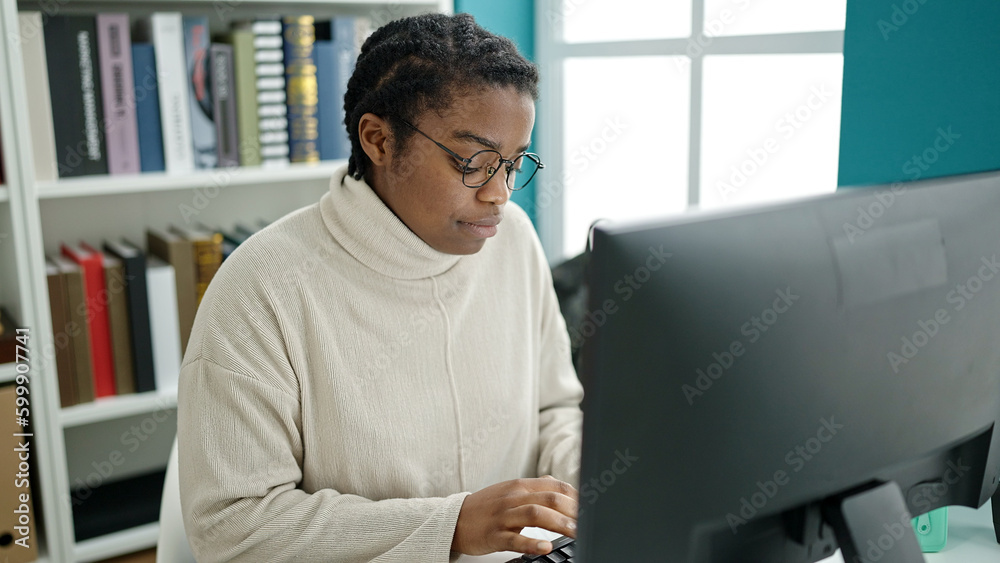 African american woman student using computer studying at library ...