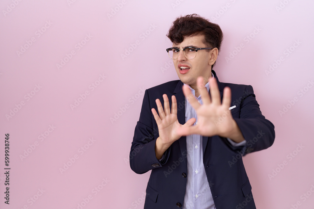 Young non binary man with beard wearing suit and tie afraid and ...