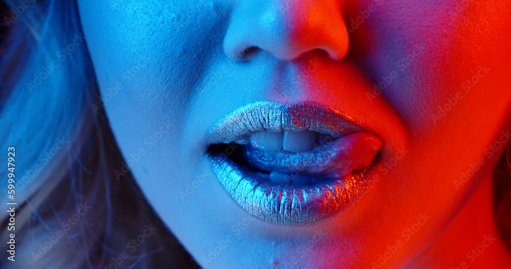 Sensual girl with bright glowing lipstick seductively licking her lips ...
