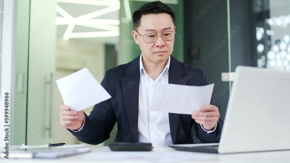 Busy accountant in formal suit holding accounts and doing financial ...