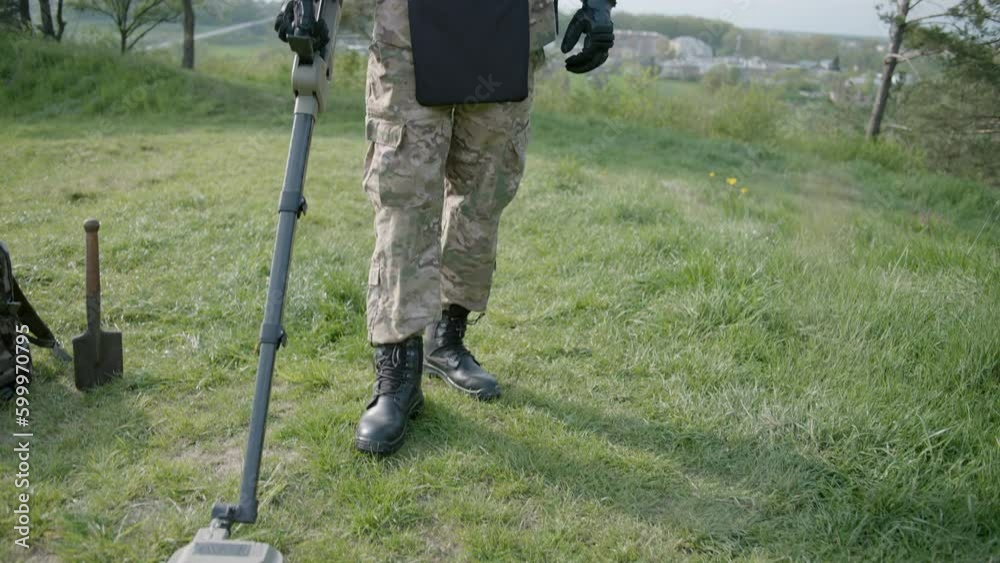 Military sapper with a metal detector in the field. Ukrainian Explosive ...