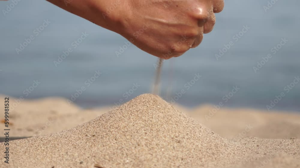 Playful woman hand throws a handful of yellow marine sand. Carefree ...