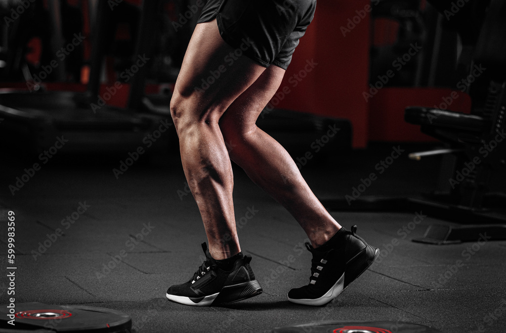 Muscular Young Man Standing in the Gym and Flexing Legs Close Up Stock ...