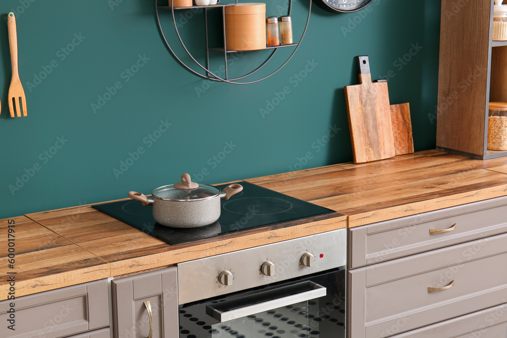 Electric stove with cooking pot and cutting board on kitchen counter ...