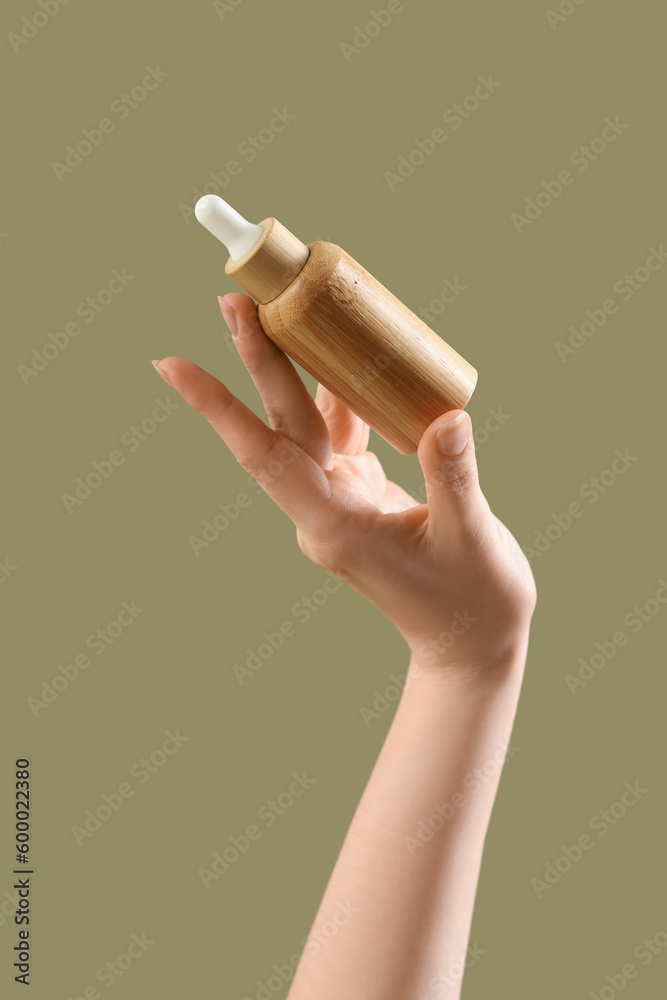 Hand holding cosmetic product on color background Stock Photo | Adobe Stock
