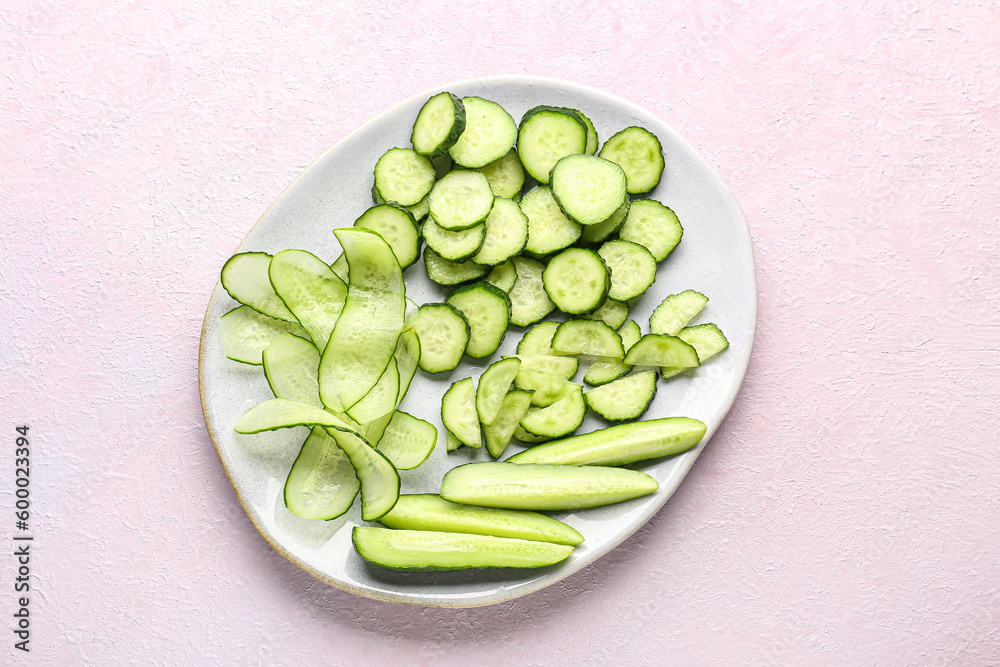 Plate with fresh cut cucumber on light background Stock Photo | Adobe Stock