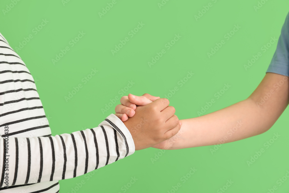 Cute little boys holding hands on green background, closeup Stock Photo ...