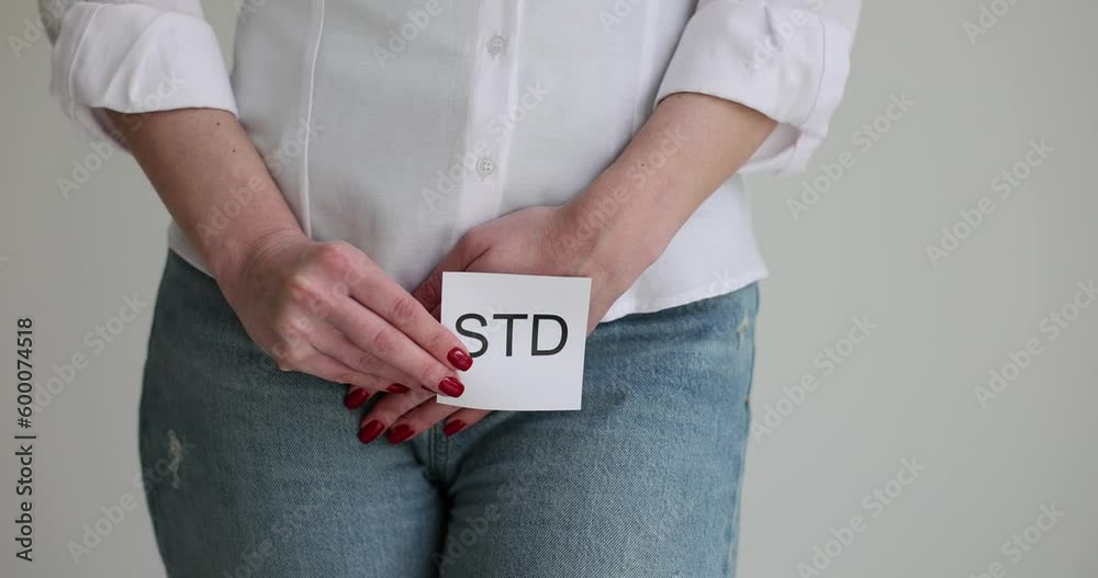Woman shows STD sign and holds genitals in pain. Sexually transmitted ...