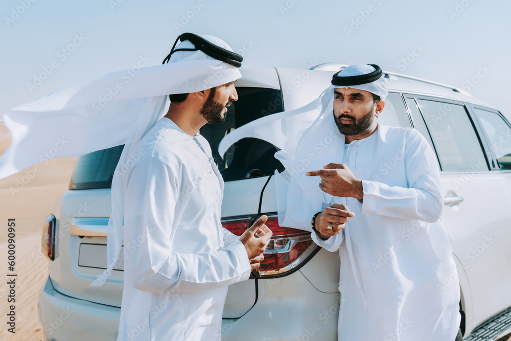 Two middle-eastern emirati men wearing arab kandura driving car in the ...