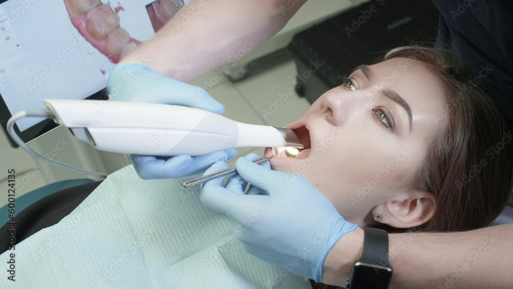 Doctor scans the patient's teeth in the clinic. The dentist holds in ...