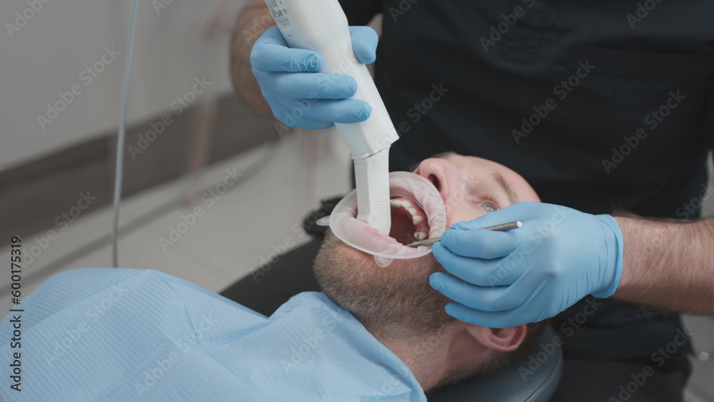 Orthodontist using 3D intraoral scanner for scanning teeth patient's ...