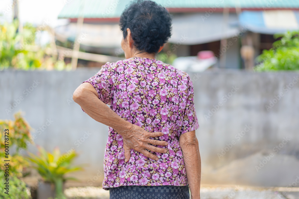 Photo of old Asian woman hands touching her back having pain in her ...