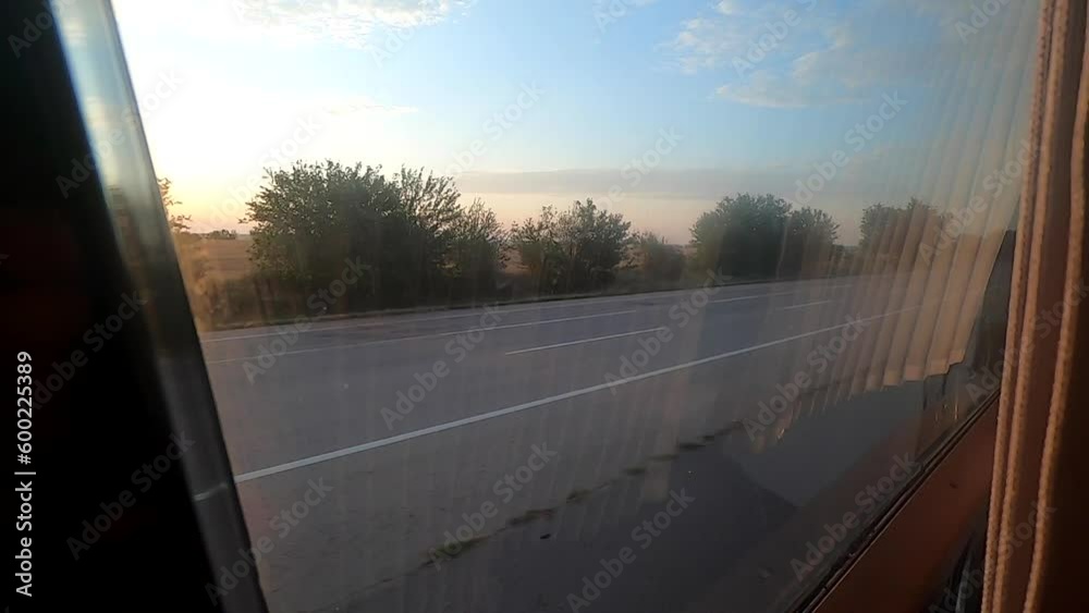 View from the bus window. View of the fields, trees, blue sky, the road ...