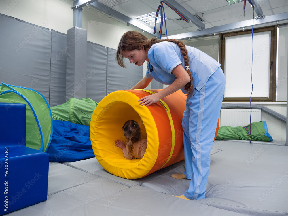 Kid girl rotation in roller tonnel during sensory integration session ...
