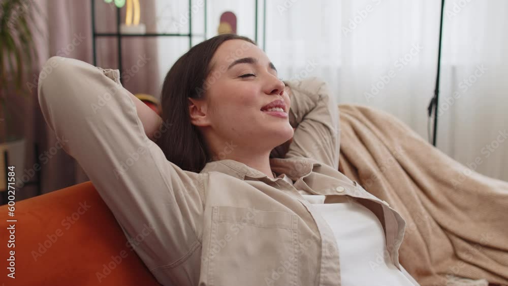 Portrait of tired young woman enjoy relaxing on home couch in room ...