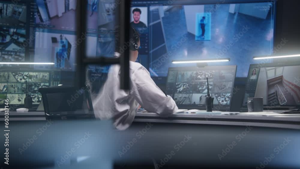 Female officer in headset monitors security cameras with AI facial ...