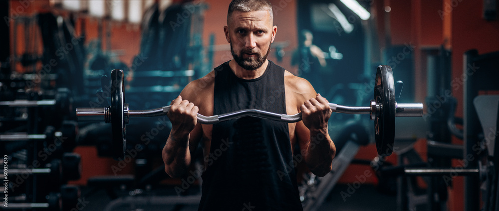 Handsome sportsman bodybuilder weightlifter with an ideal body, poses ...