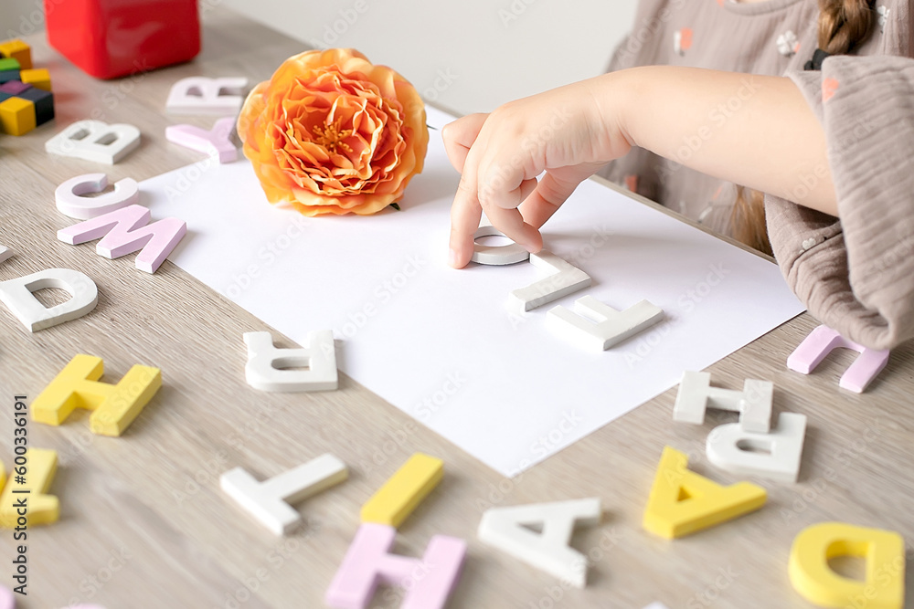 school girl trying to make a word. Kids learn to read. Colorful letters ...